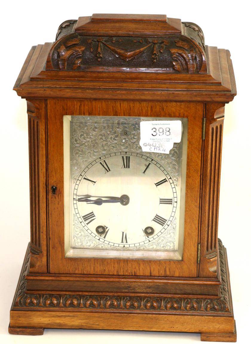 Lot 398 - An oak striking carved mantel clock, circa