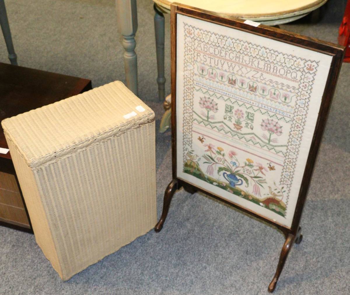 Lot 1057 - A fire screen with an inset sampler to one