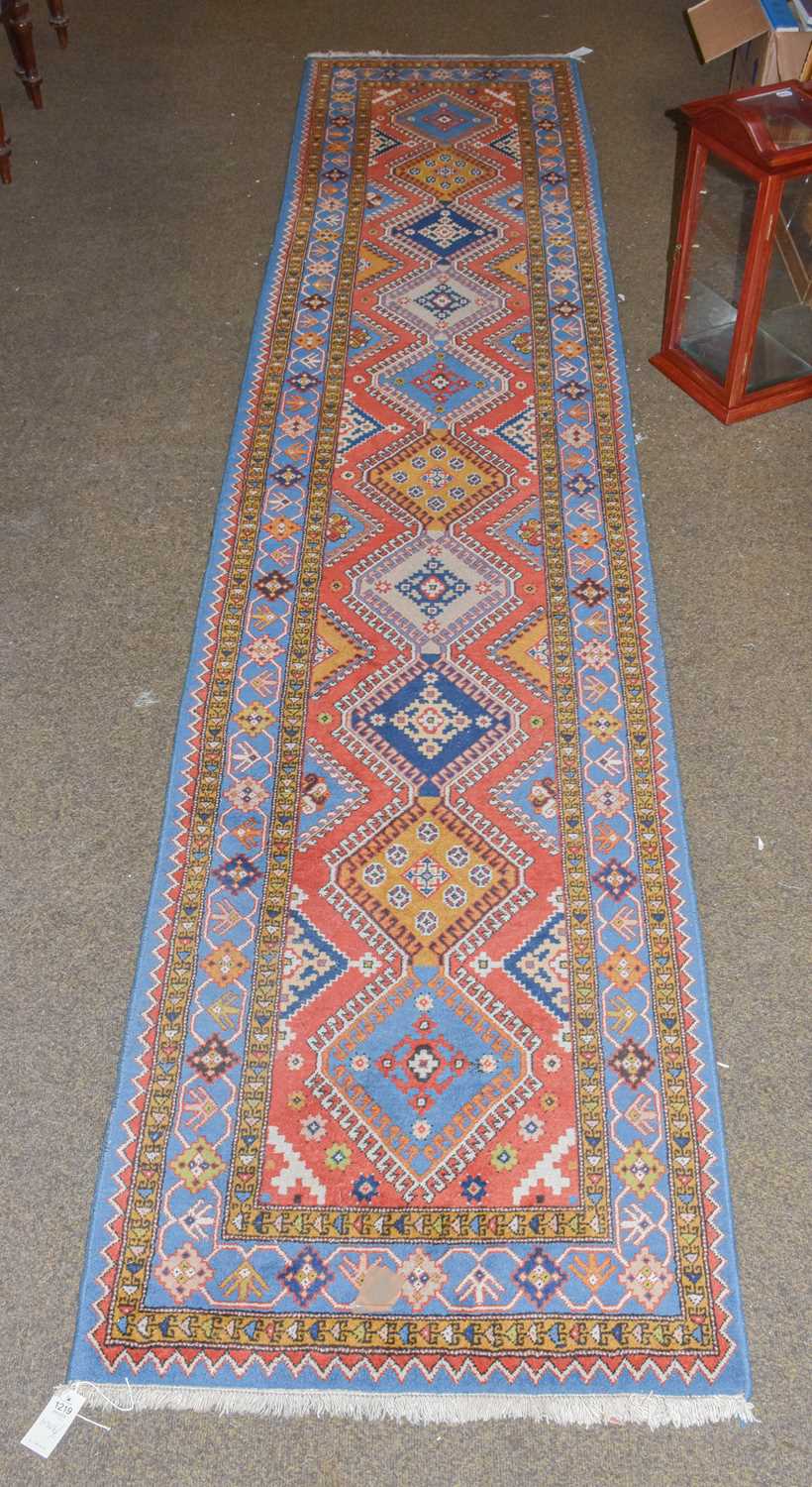 A multi-coloured runner with diamond form decorated centre and a zig ...