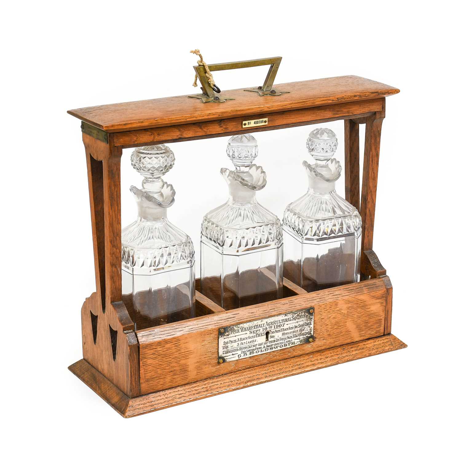 Lot 209 - An Oak Three-Bottle Tantalus, circa 1907, of