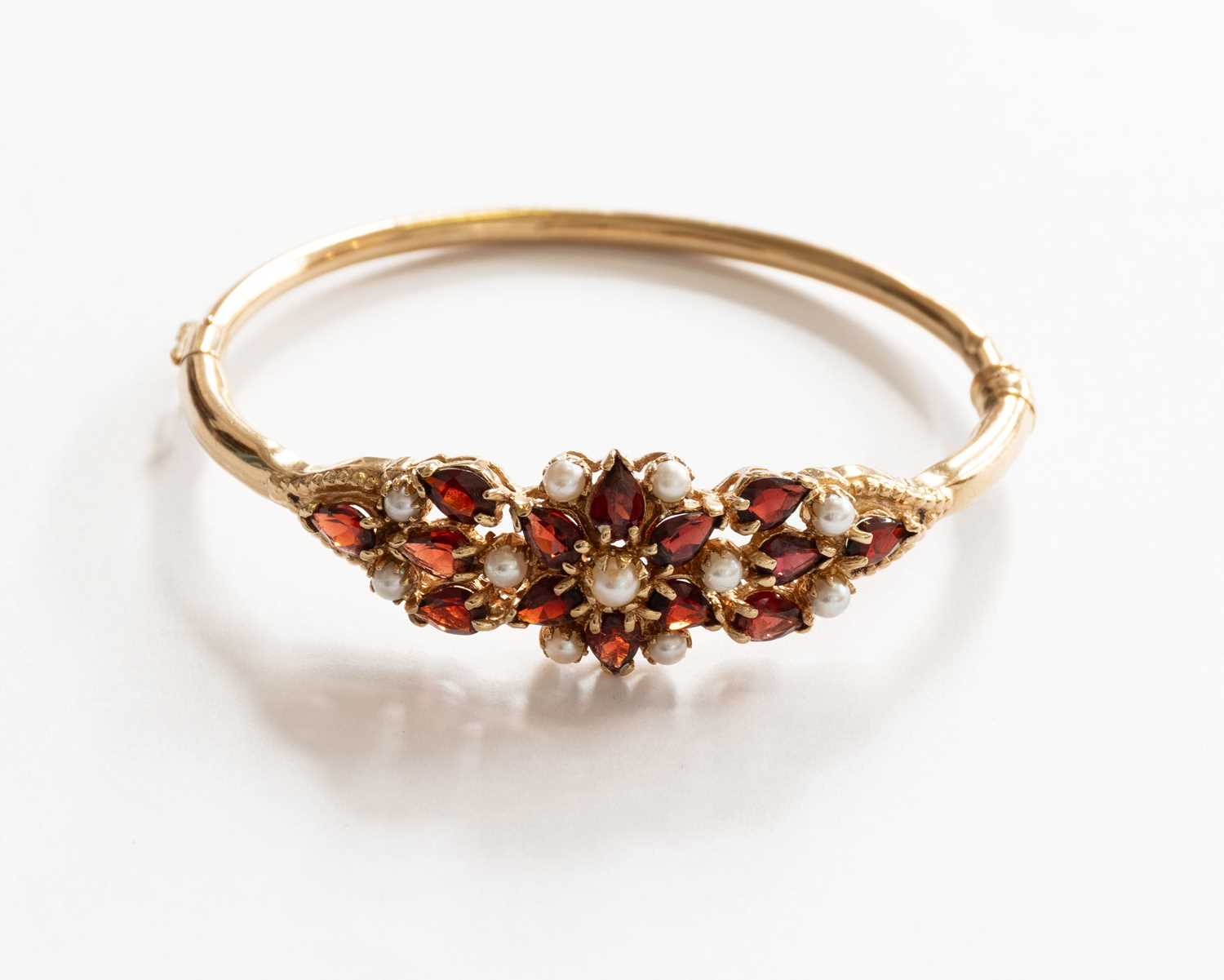 Lot 385 - A Garnet and Cultured Pearl Bangle, stamped