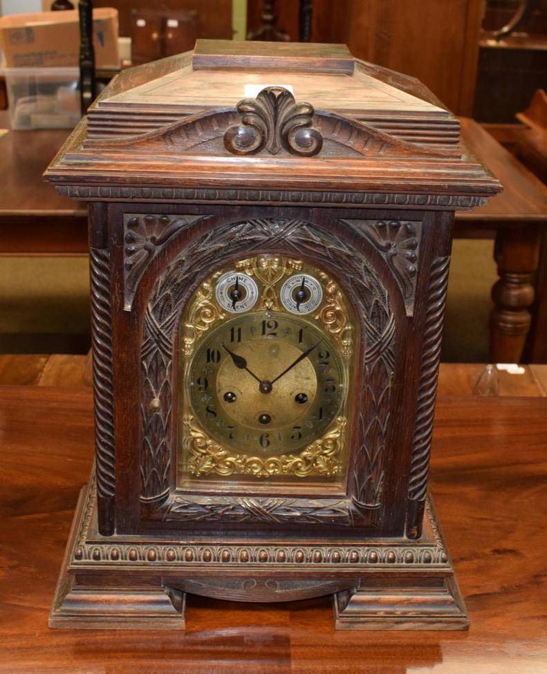 Lot 455 - ~ Carved oak quarter striking mantel clock,