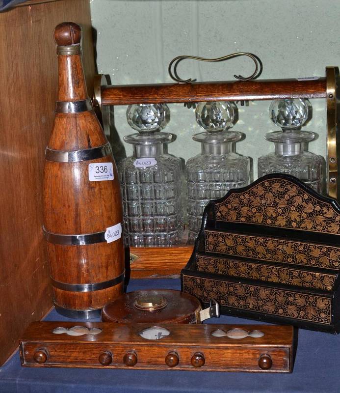 Lot 336 - An oak three bottle tantalus, a latter rack,